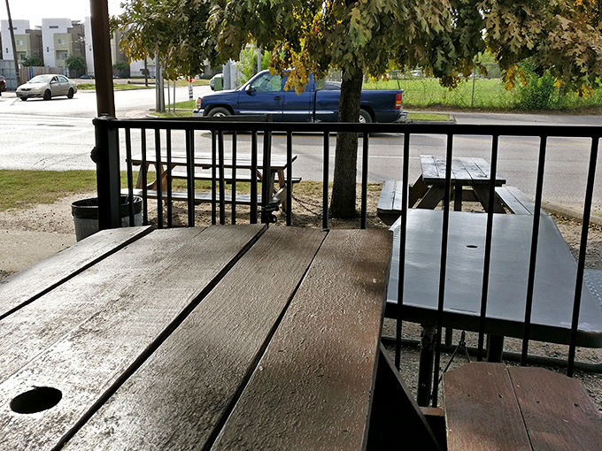 Picnic tables under pergolas create the perfect setting for savoring burgers that deserve serious contemplation time.