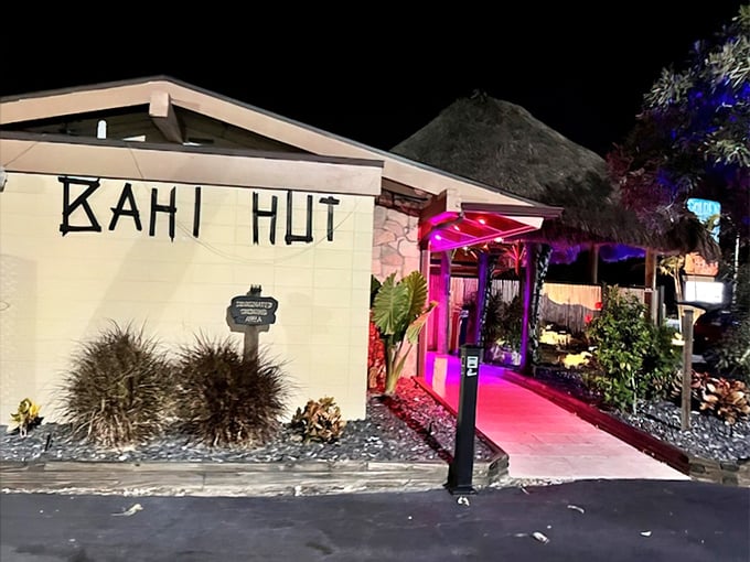 Evening exterior lighting transforms the building into a glowing tropical beacon visible throughout the neighborhood streets.
