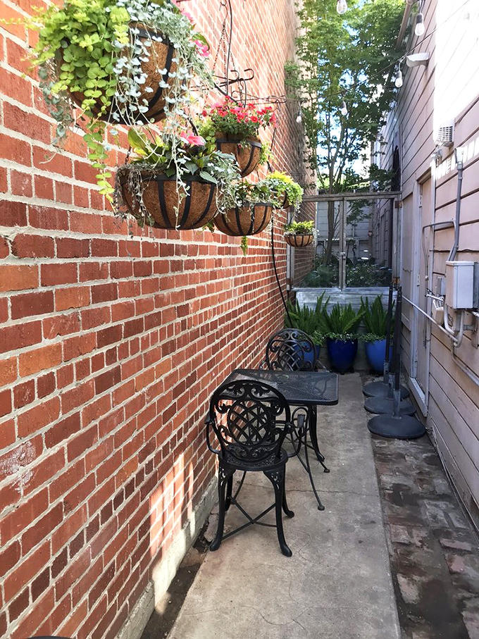 The secret alleyway seating area feels like discovering a hidden garden where hanging plants create a verdant escape from urban life.