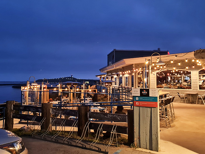 As night falls, the outdoor deck transforms into a twinkling wonderland where seafood and starlight create perfect California moments.