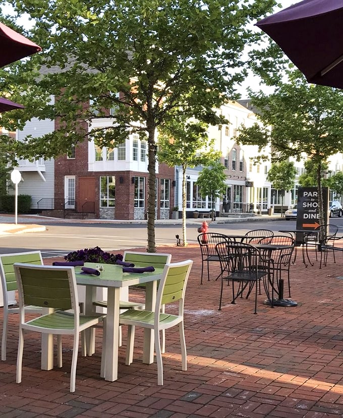 Outdoor dining that captures the essence of small-town charm &ndash; brick pathways, green chairs, and the gentle rustle of leaves overhead.