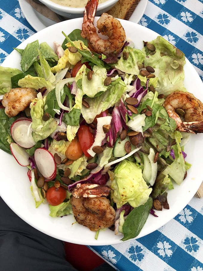 A salad that understands its purpose: to showcase plump shrimp while providing just enough greenery to justify ordering dessert afterward.