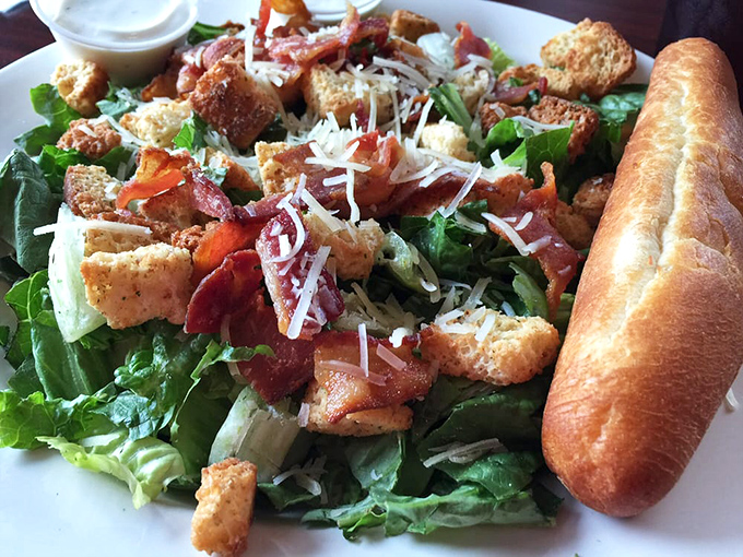 A salad that doesn't apologize for being delicious. Crisp greens, bacon bits, and that breadstick standing guard like a carb sentinel.