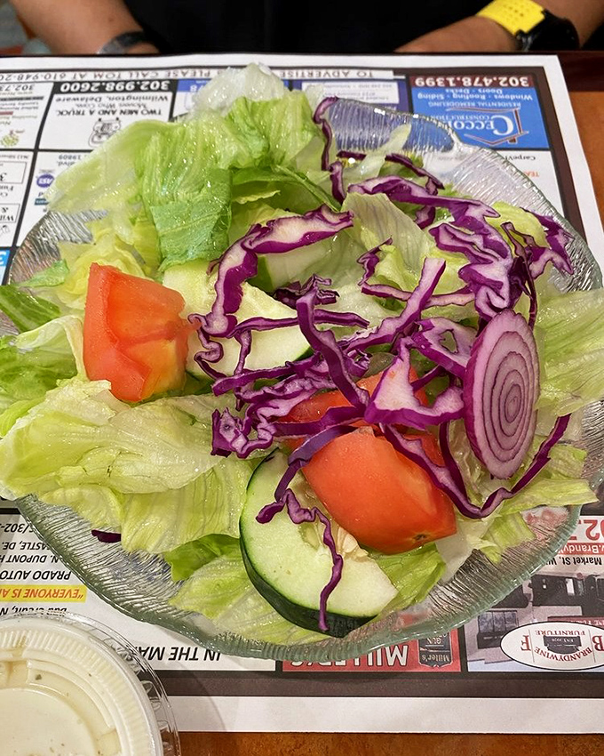 A garden party in a glass bowl, where crisp lettuce, purple cabbage, and tomato gather to remind you that sometimes, salad isn't just what food eats.