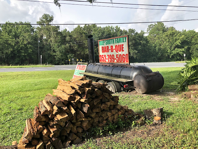 The smoker and woodpile outside tell the real story of low-and-slow barbecue dedication.