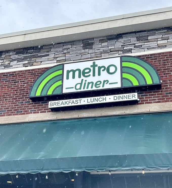 Snow falls gently around the Metro Diner sign, proving that comfort food knows no season. Pancakes taste even better when there's weather happening.