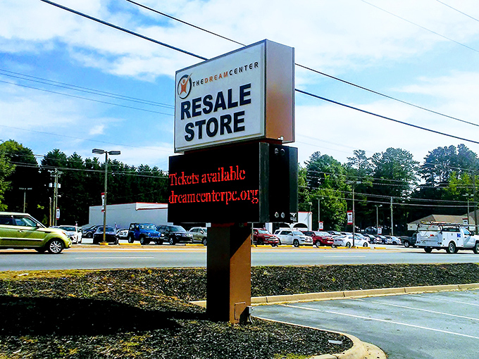 The roadside sign stands as a beacon to bargain hunters, promising treasures inside and supporting community programs outside.