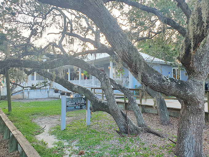 Nature frames the entrance like it's showing off a favorite child. That oak tree has probably seen more first dates and anniversaries than a wedding planner.