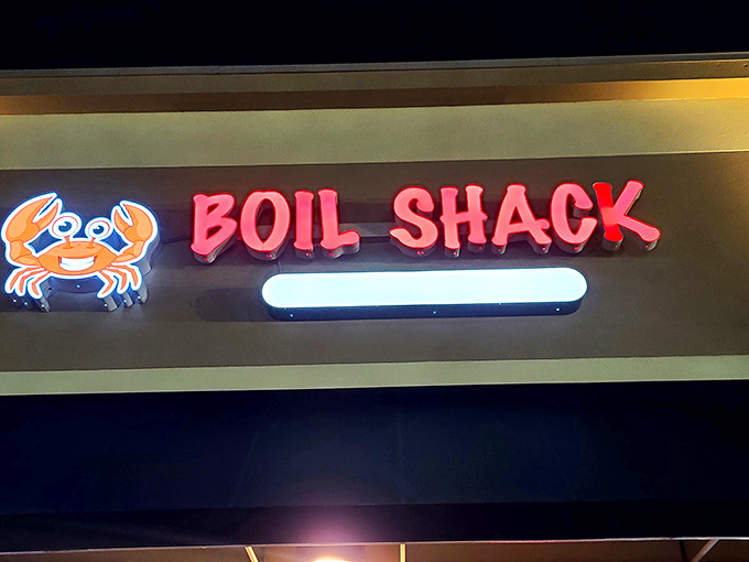 The neon sign glows like a lighthouse beacon for hungry travelers, with that cheerful crab mascot practically winking at passersby.