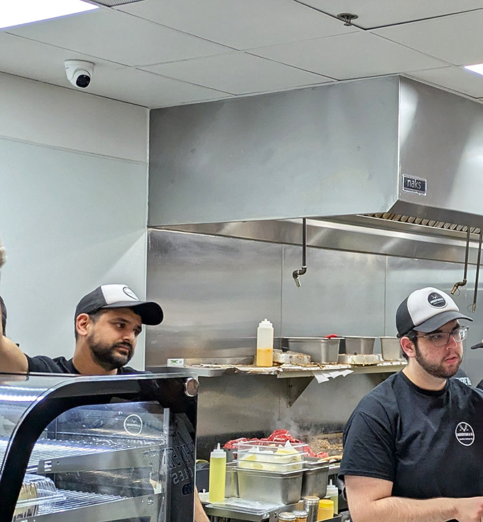 The sandwich artisans at work. Not all heroes wear capes&mdash;some wear caps and create edible masterpieces on a hot griddle.