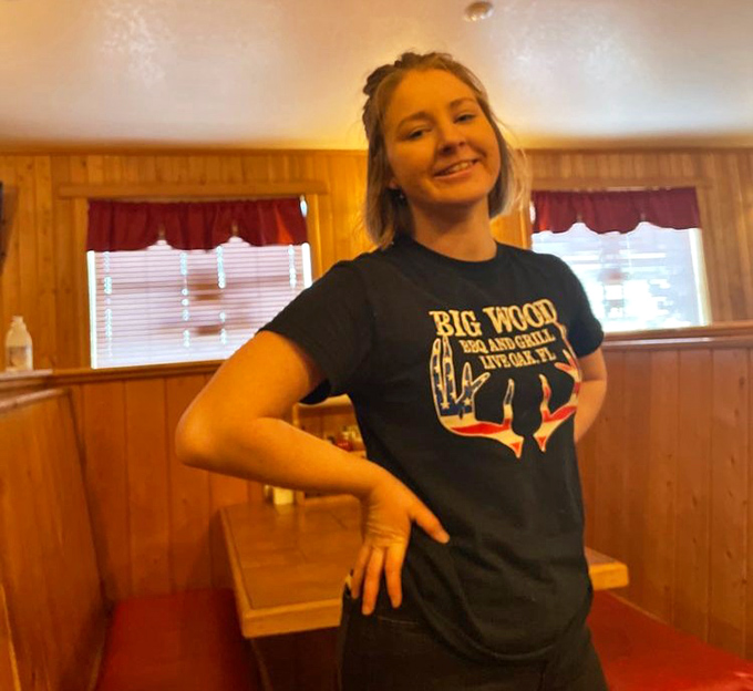 The smile of someone who knows she's delivering happiness on a plate. Big Wood's staff carries the torch of Florida's barbecue tradition with pride.
