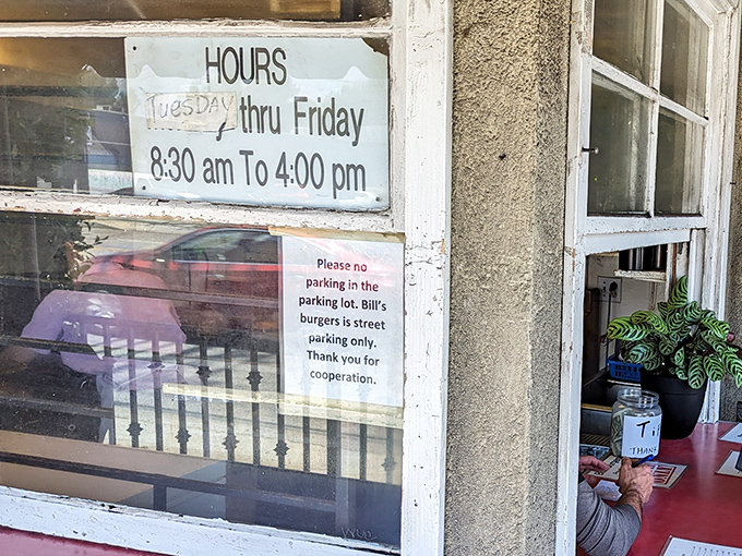 The hours sign tells you everything you need to know about priorities: burgers first, conventional business hours second.