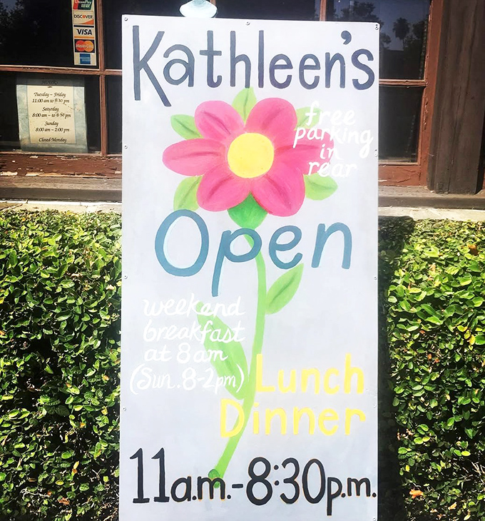 The cheerful flower sign announces hours with a splash of color, promising weekend breakfast that starts early enough for even the hungriest early birds.