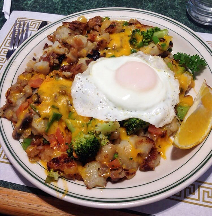 The legendary Nest Egg in all its glory—home fries loaded with veggies, melted cheese, and that perfect sunny-side egg. Breakfast architecture at its finest.
