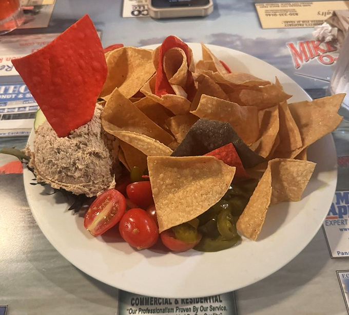 Tuna dip surrounded by a fortress of tortilla chips. The cherry tomatoes and pickles aren't just garnish&mdash;they're essential supporting characters in this flavor play.