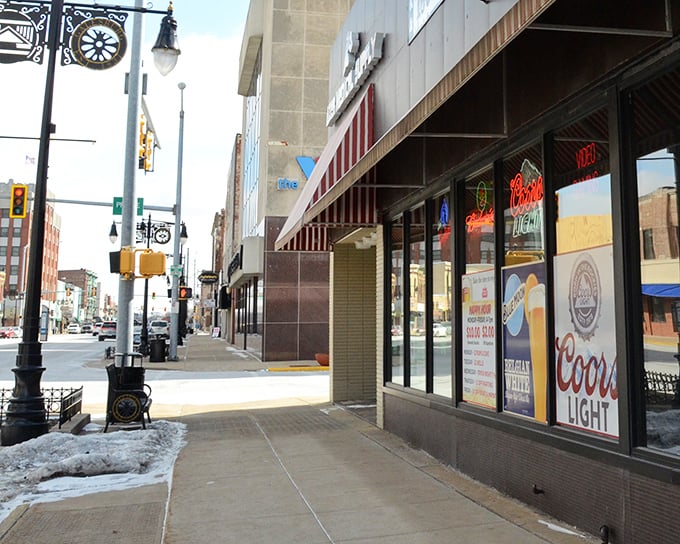 Downtown storefronts maintain their historic charm while housing modern businesses, where neon beer signs glow against century-old architectural details in perfect Midwestern harmony.