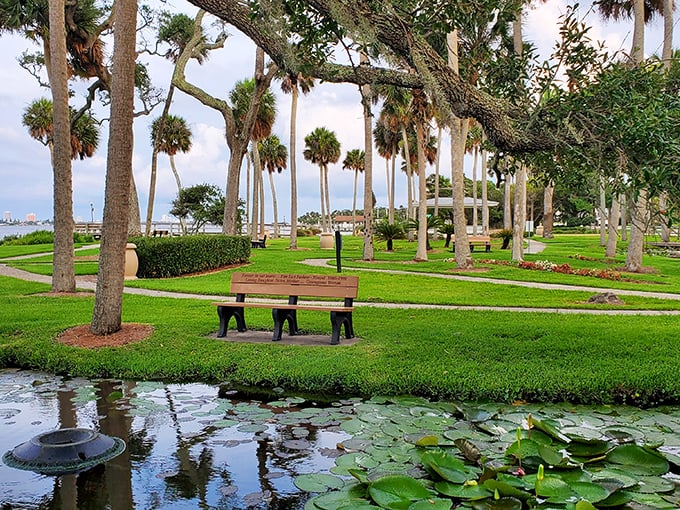 Park benches positioned for maximum contemplation among palm trees and lily pads &ndash; nature's version of the perfect living room arrangement.