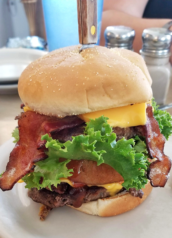 This isn't just a bacon cheeseburger—it's a towering monument to the art of proper American indulgence, complete with a knife to hold it together.