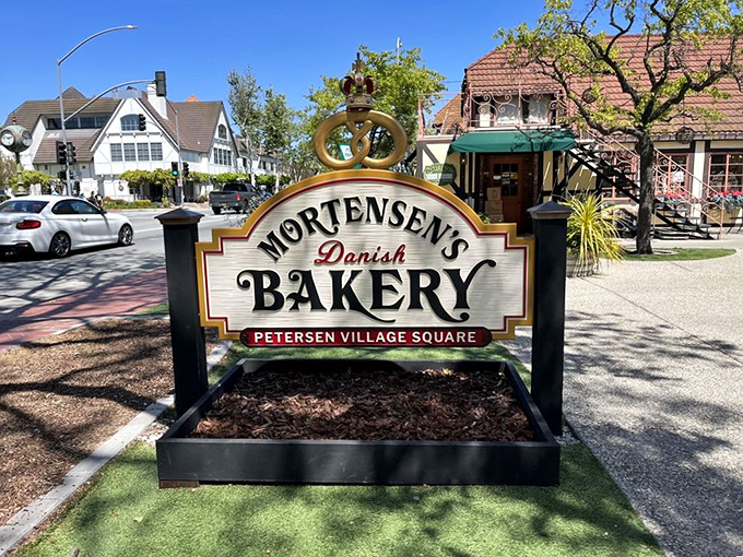 The bakery's crown-topped sign stands as a landmark in Petersen Village Square, guiding hungry pilgrims to their buttery salvation.