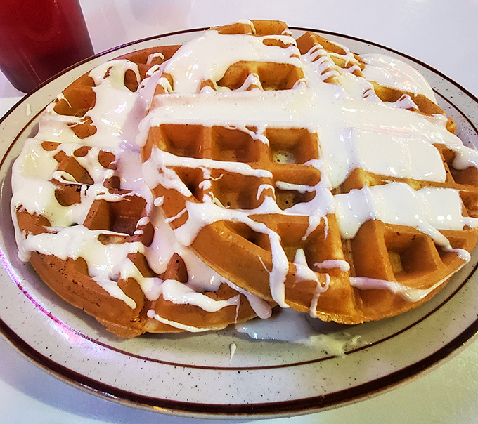 A Belgian waffle wearing its Sunday best &ndash; dressed in cream that's melting like your resolve to "just have a bite."
