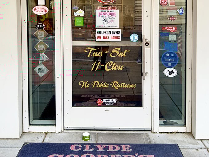 Hours posted with Southern directness. That "Hell Froze Over! We Take Cards" sign tells you everything about this place's delightful stubbornness.