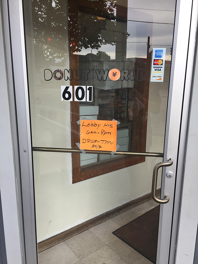 Business hours posted with Midwestern straightforwardness. The orange paper sign might as well read "Hours When Happiness Is Available."