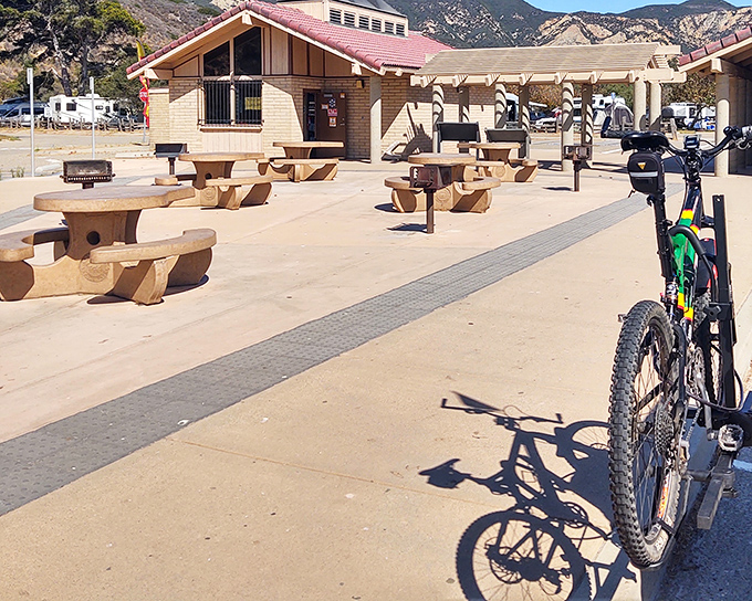 Concrete picnic tables that have hosted more family gatherings than your aunt's dining room, with mountains standing in as nature's wallpaper.