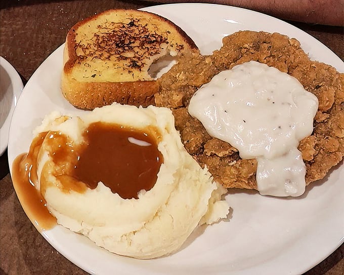 Chicken fried steak with gravy pools in mashed potatoes&mdash;a plate that says "you won't need dinner" with the confidence of a heavyweight champion.