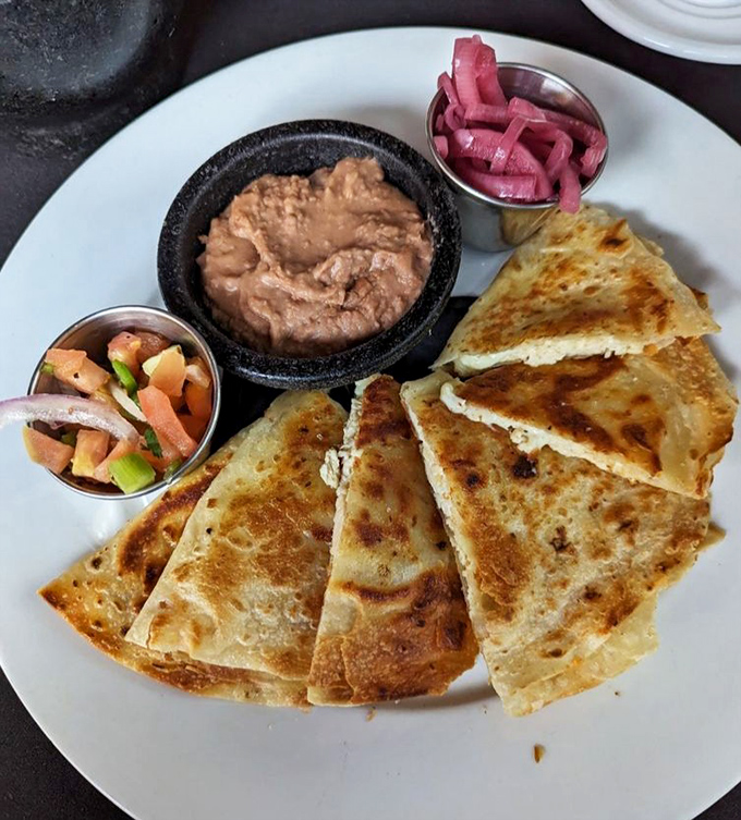 The humble quesadilla gets the royal treatment with perfectly browned tortillas, creamy beans, and pickled onions that mean business.
