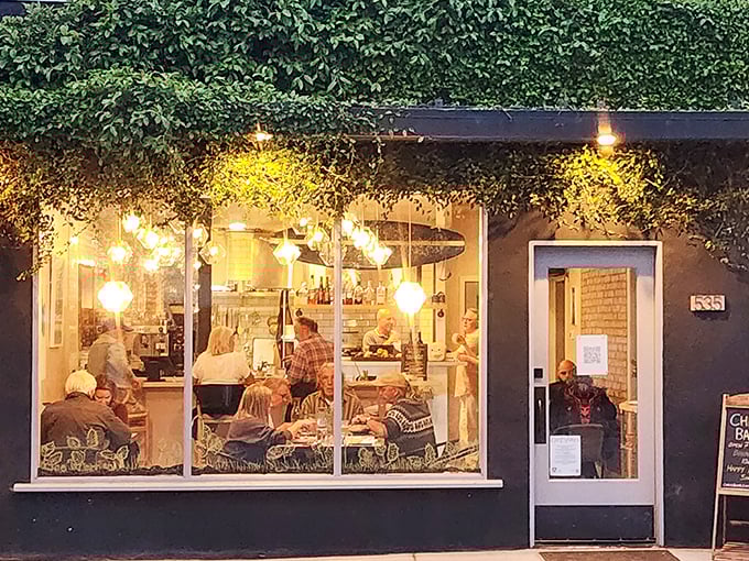 This cozy restaurant window frames the perfect retirement evening &ndash; good food, warm light, and not a single urgent email in sight.