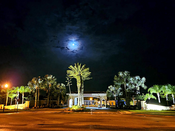 Palm trees frame the entrance under a dramatic night sky, welcoming visitors to this slice of European elegance in the Sunshine State.