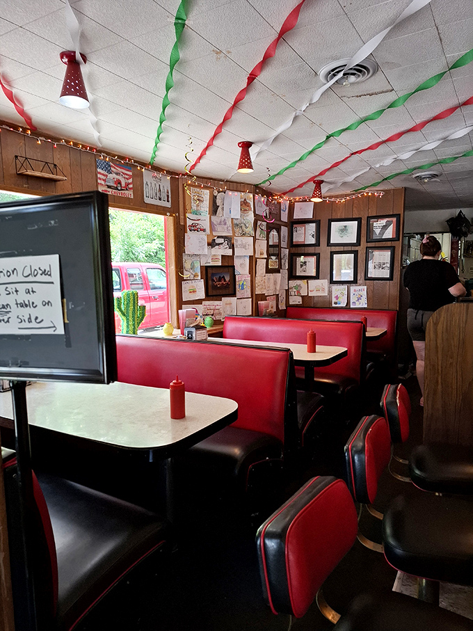 The wall of memories tells stories of satisfied customers past, while red booths stand ready to host the next chapter of your personal burger journey.