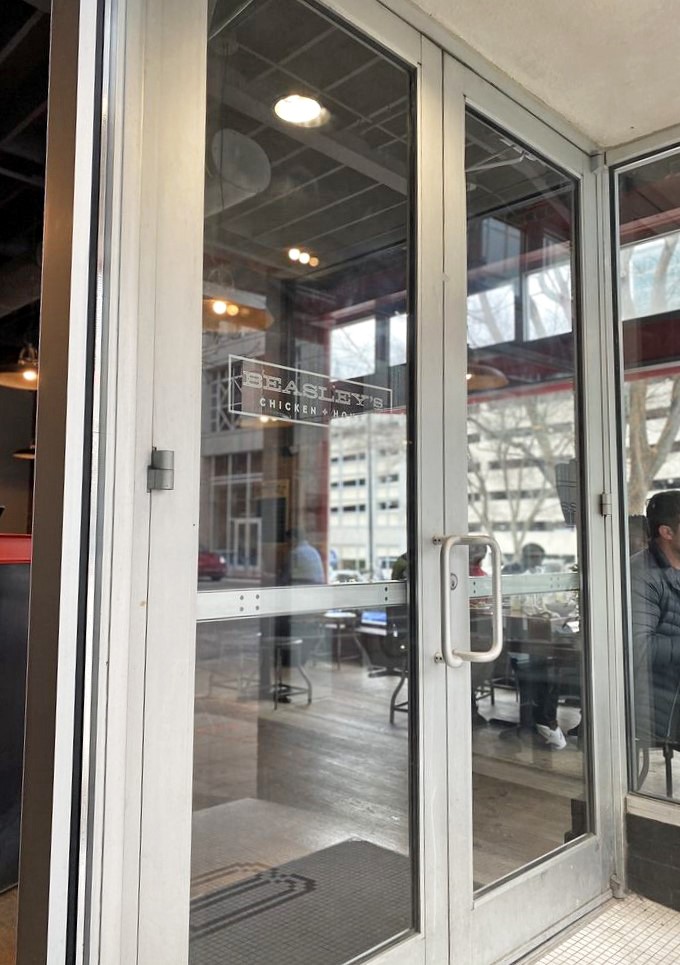 The entrance to flavor paradise, where the simple etched "Beasley's Chicken + Honey" on glass promises delights that exceed your highest expectations.