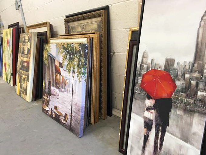Leaning frames create an impromptu gallery wall. That couple with the red umbrella has no idea they're about to decorate someone's hallway. 