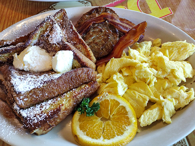 French toast dusted with powdered sugar, alongside eggs and bacon&mdash;the breakfast trifecta that's been solving problems since before therapy was cool.