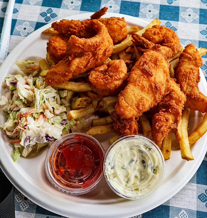 The holy trinity of fried seafood perfection: golden shrimp, crispy fries, and creamy coleslaw. This plate is why elastic waistbands were invented.