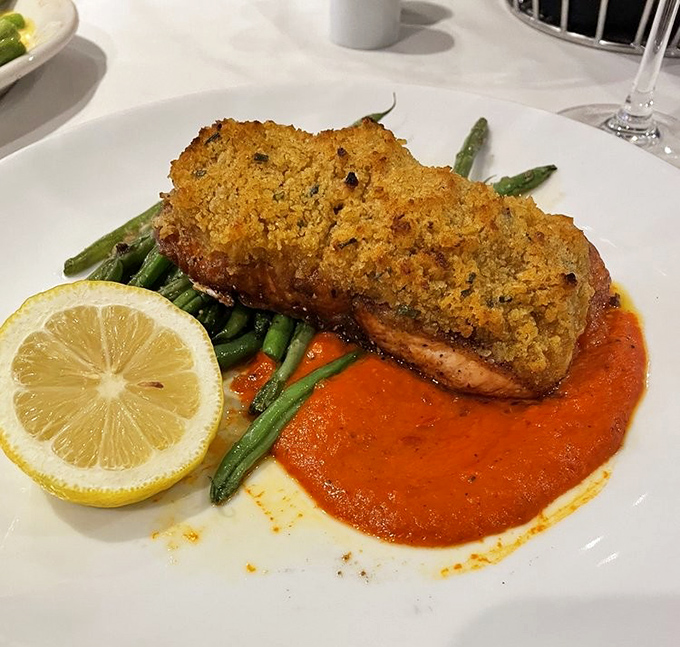 Salmon wearing a golden crust like it's dressed for the Oscars. The vibrant sauce below creates a red carpet moment for your taste buds.