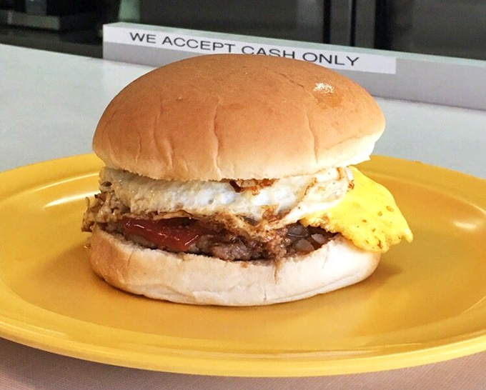 The breakfast sandwich that launches a thousand productive mornings. Egg, meat, and cheese on a soft bun&mdash;simple perfection on a yellow plate.