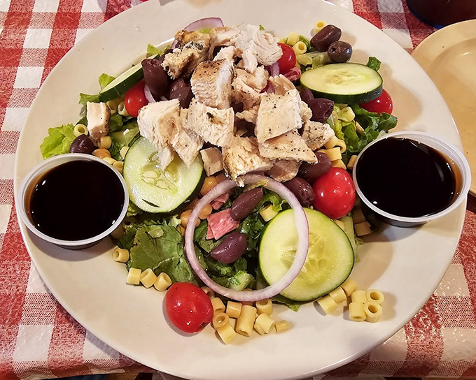 A salad that's trying to be healthy while hanging out with pasta, olives, and dressing. It's the culinary equivalent of wearing sneakers with a tuxedo.