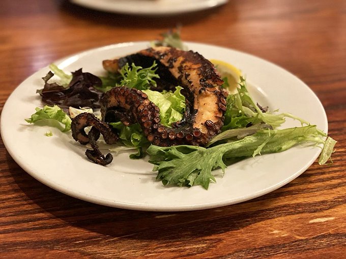 Grilled octopus: the ultimate test of a Greek kitchen's prowess. Perfectly charred tentacles rest on fresh greens&mdash;simple, authentic, and utterly magnificent.