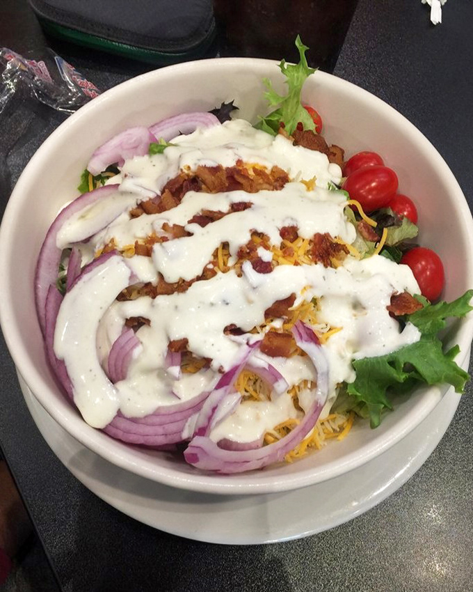 A house salad that actually deserves the title—crisp greens, vibrant veggies, and a dressing that doesn't just coat but actually complements.