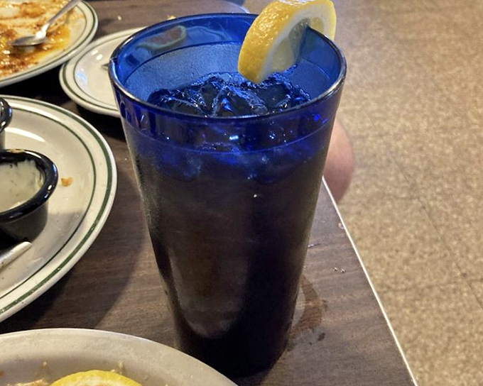 An Arnold Palmer in that signature blue glass—half tea, half lemonade, all refreshment. The lemon slice isn't garnish; it's an exclamation point.