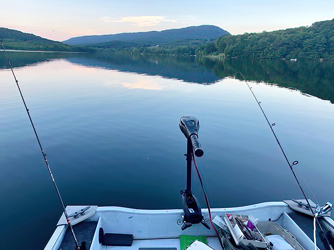 Dawn fishing that makes waking up at 5 AM completely worth it. The glass-like water reflects mountains and sky in a display no filter could improve.
