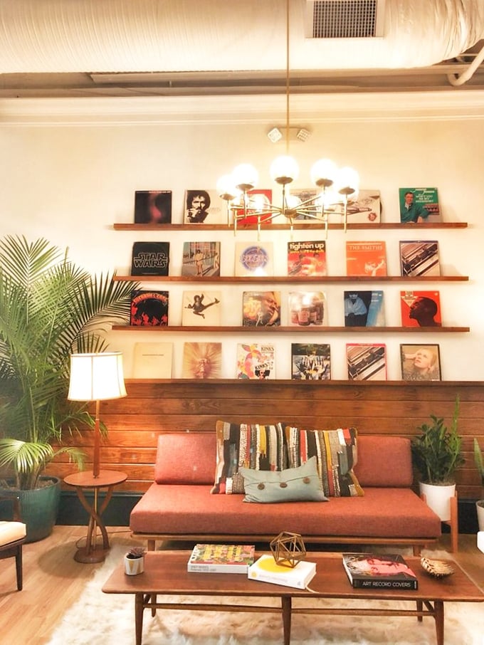 The lounge area with its vinyl record display, mid-century furniture, and plants feels like the coolest friend's living room&mdash;if that friend also served amazing breakfast.