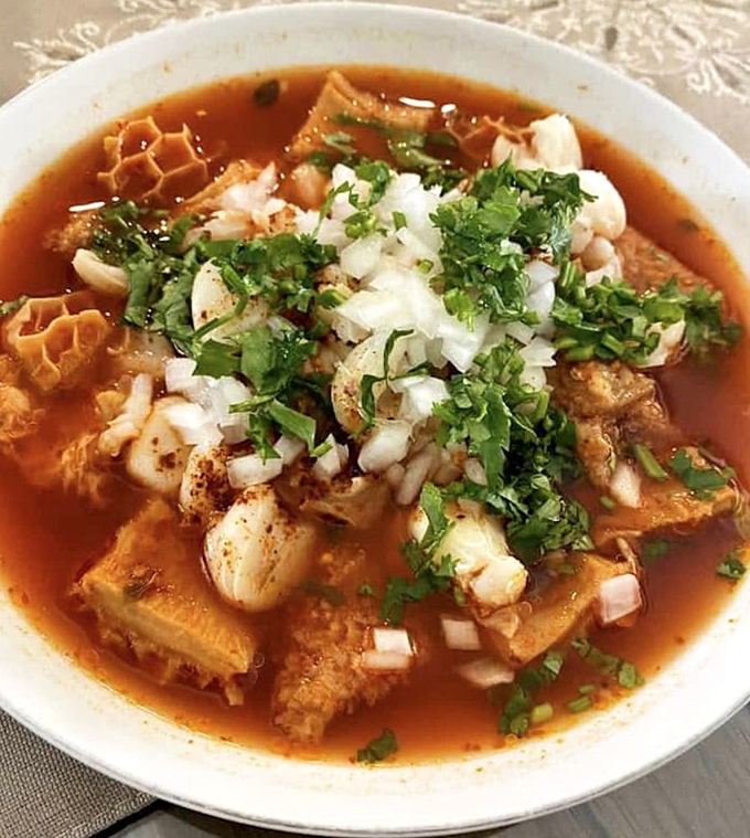 Menudo: the legendary soup that's equal parts tradition and revelation, topped with fresh cilantro and onions for the perfect finish.