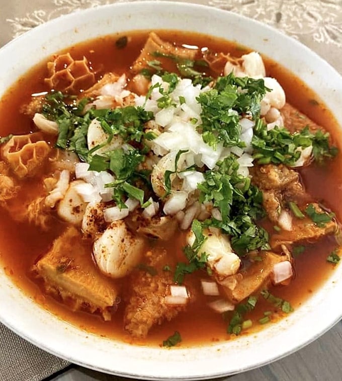 Menudo: the legendary soup that's equal parts tradition and revelation, topped with fresh cilantro and onions for the perfect finish.