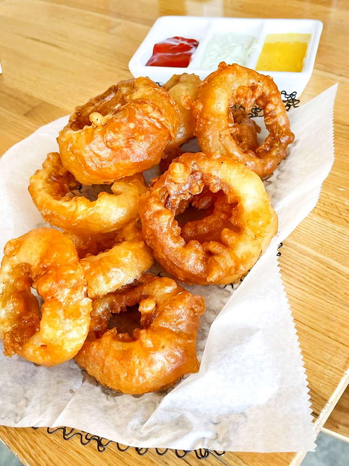 These aren't just onion rings&mdash;they're golden halos of crispy perfection, waiting to be dipped in that trio of sauces for flavor enlightenment.