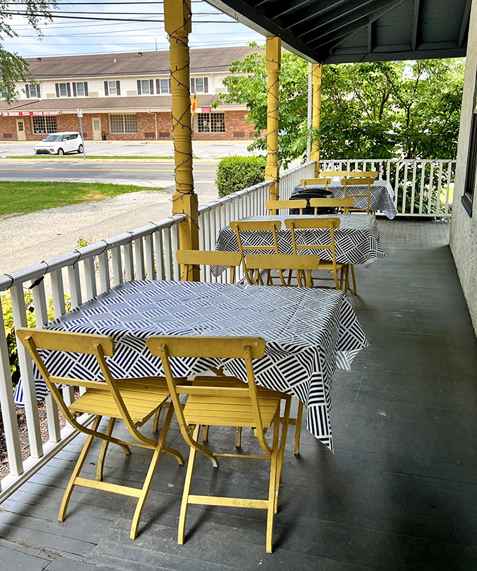 Outdoor dining with a side of small-town charm. Those cheerful yellow chairs and black-and-white tablecloths create the perfect setting for savoring both food and conversation.