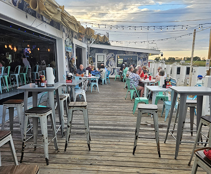As evening approaches, string lights transform the patio into a magical waterfront dining room where conversations flow as freely as the drinks.