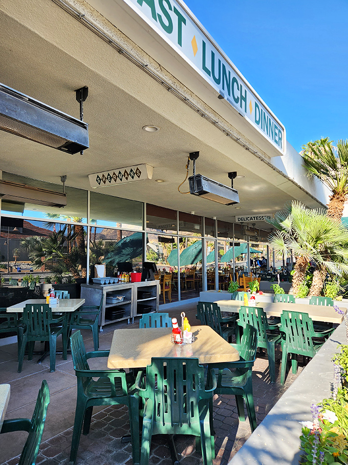 Palm trees provide shade for outdoor diners enjoying their mile-high sandwiches in the quintessential Palm Springs setting.